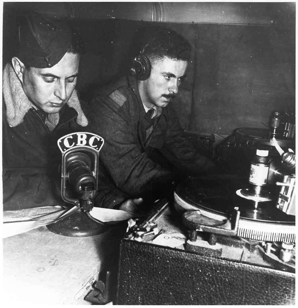 Two correspondents in military uniform, broadcasting news for the CBC ...