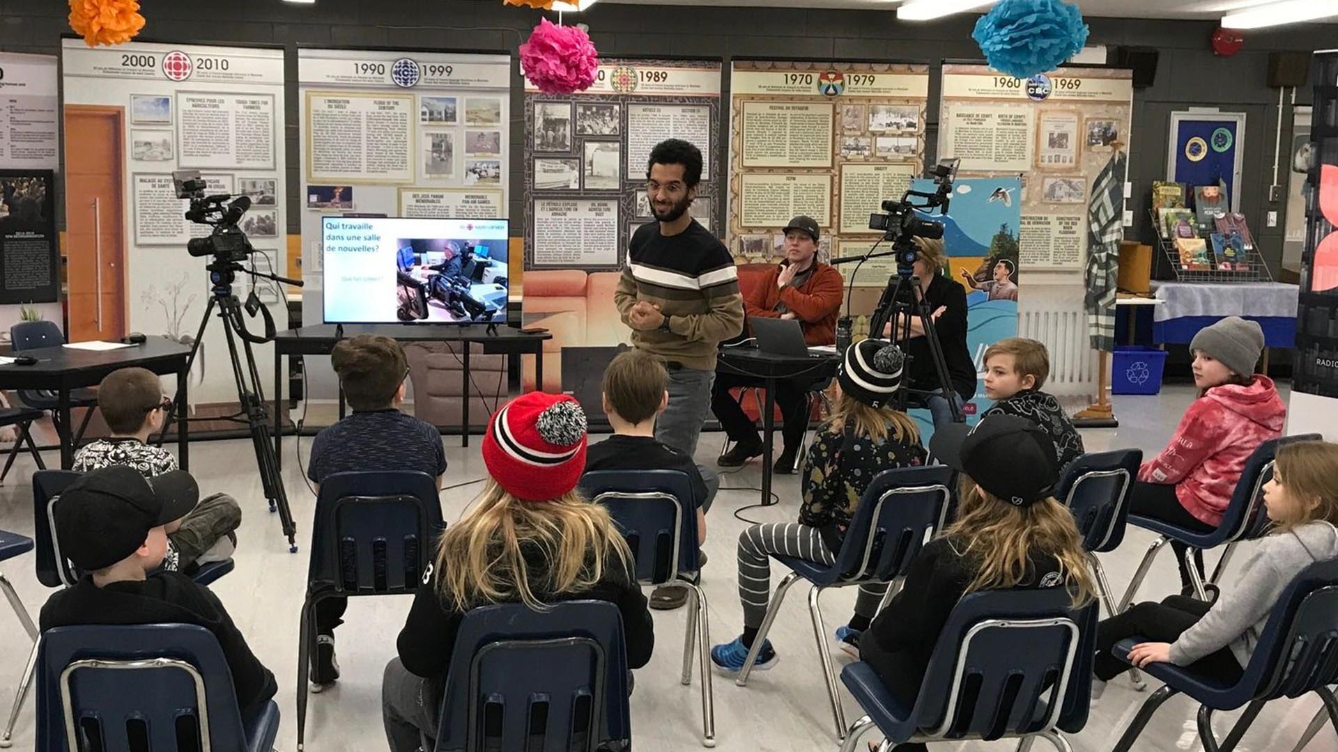 A CBC employee is presenting to a group of small children in the ...