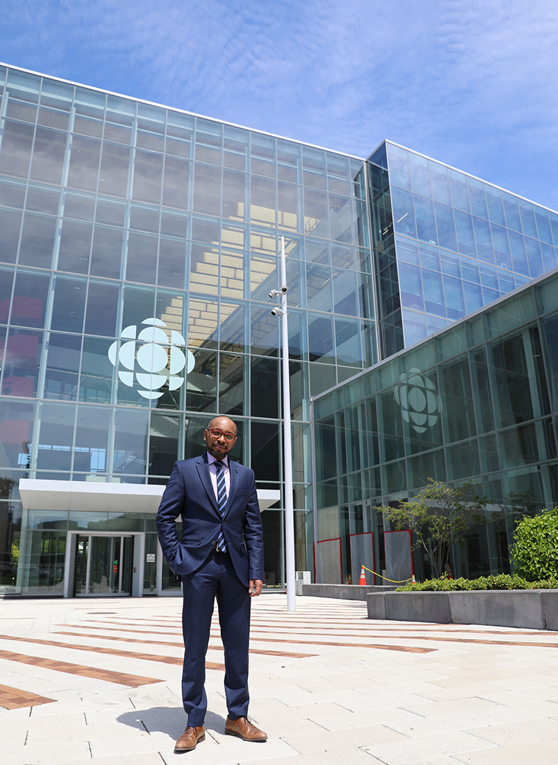 Waldir Da Cruz standing in a blue suit outside of the MRC building