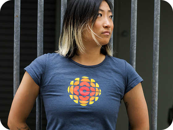 A woman dressed in a blue shirt with a CBC/Radio-Canada orange, yellow ...