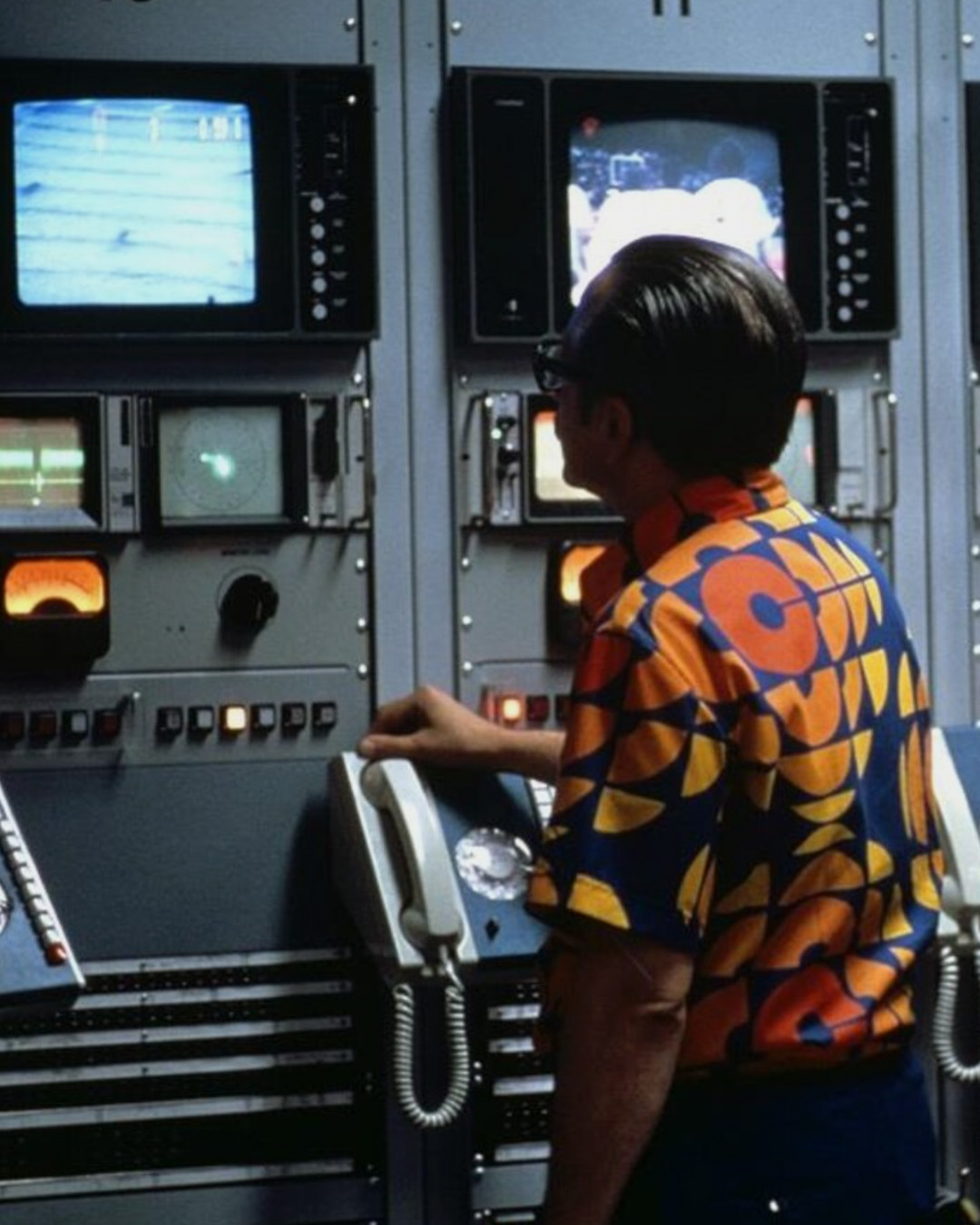 Two TV operators looking at the display of their equipment, wearing ...