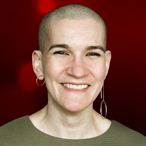 April Hubbard wearing a green sweater and gold earrings