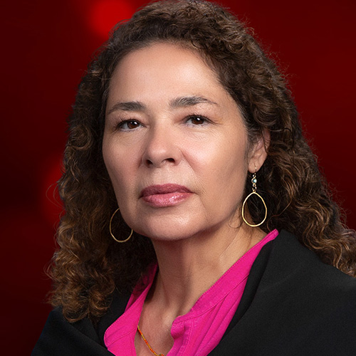 Sandra Laronde wearing a fucia blouse and a black jacket and gold hoop ...