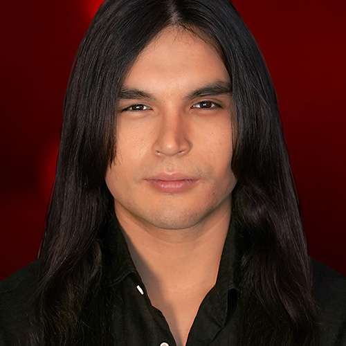 Joshua Odjick with long black hair wearing a black button down shirt